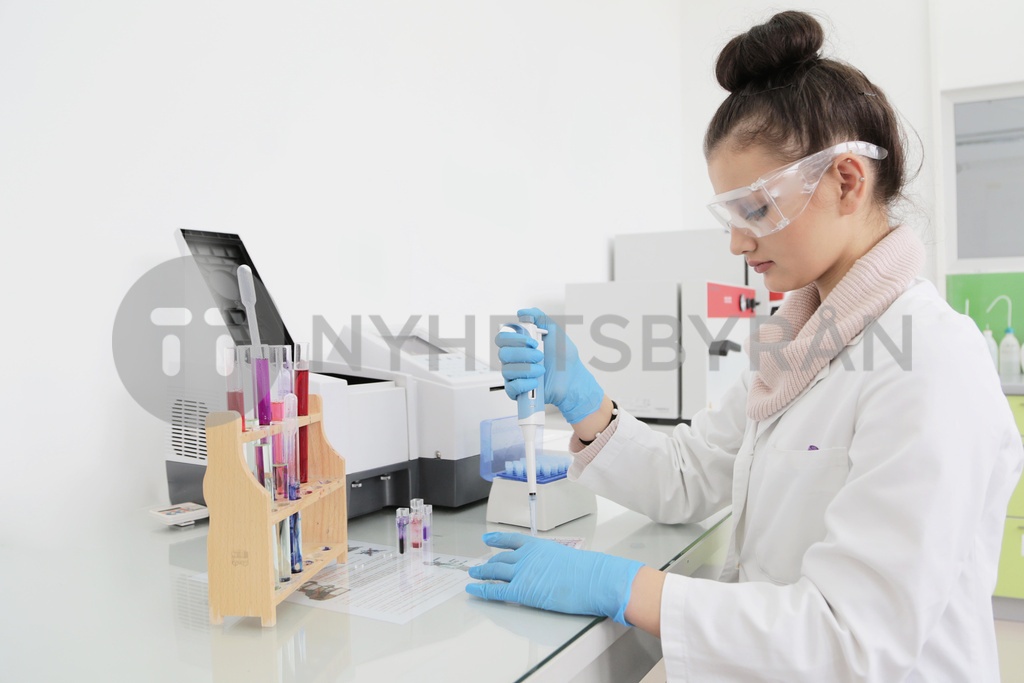 Young female Laboratory scientist working at lab with test tubes and ...
