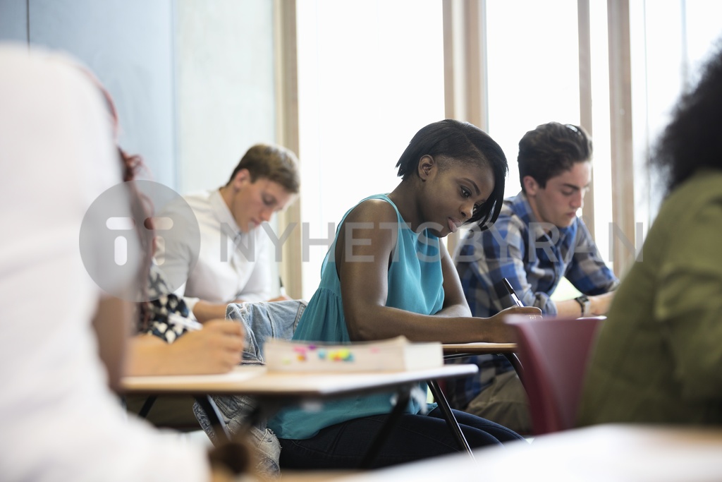 View of students sitting at desks during test in classroom