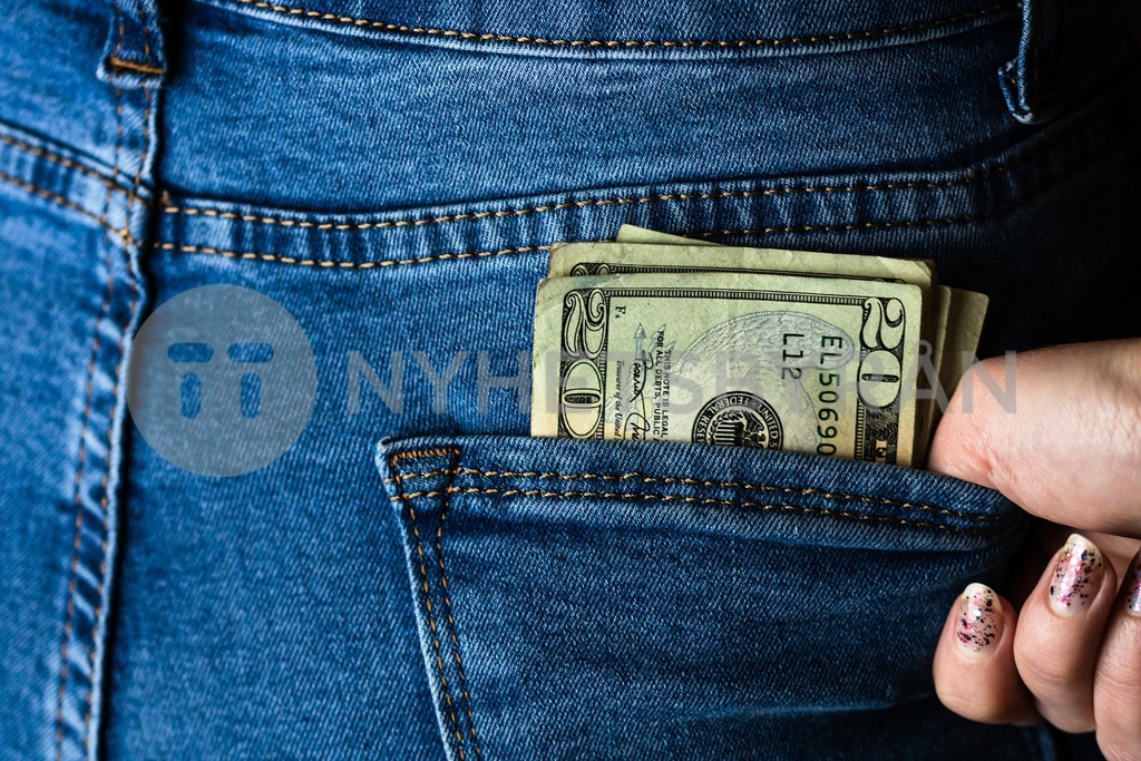 Teenage girl grabs dollar banknotes from her back pocket. Banknotes ...