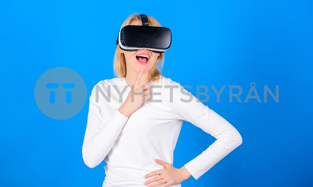 Cheerful smiling woman looking in VR glasses. Woman with virtual reality headset. Happy woman ...