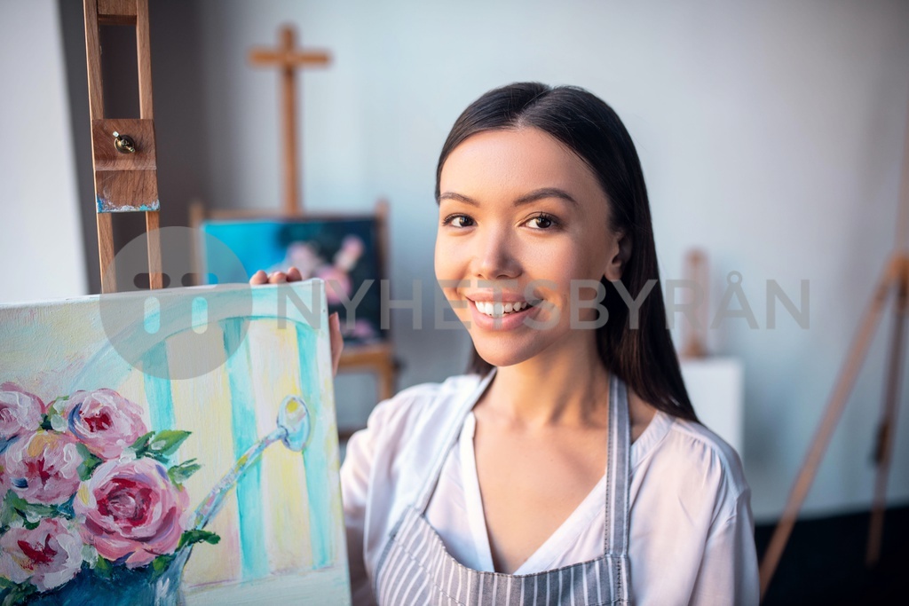 Positive happy woman showing her beautiful painting
