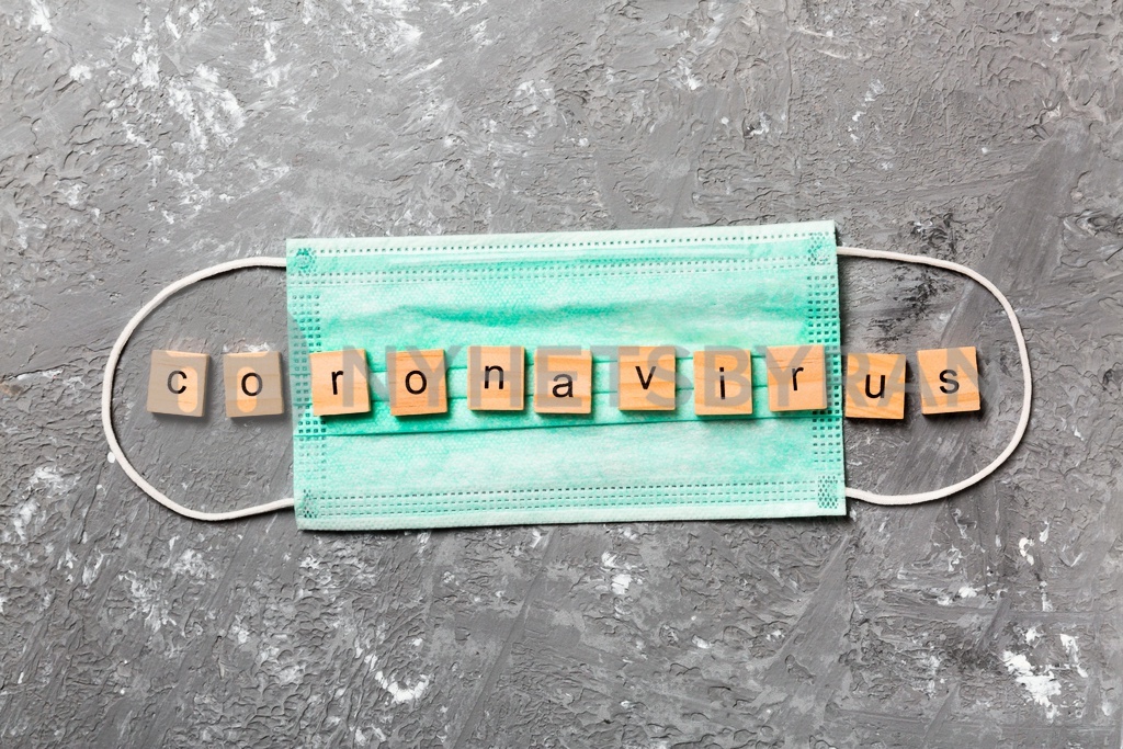 coronavirus word written on wood block lying on medical mask ...