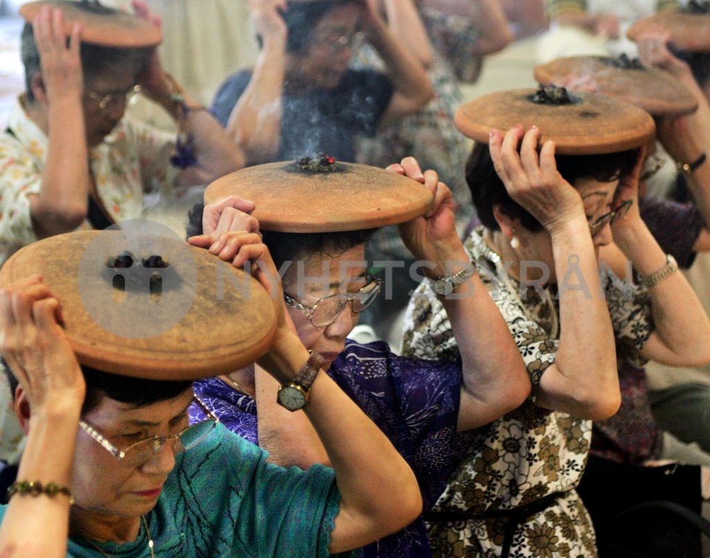 Smoke rises from moxa burning on plates placed on women's heads in ...