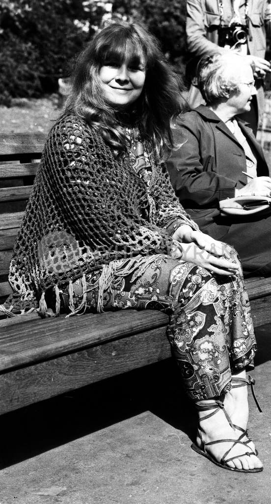Folk singer Sandy Denny sitting on a park bench