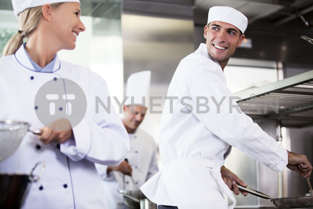 Chefs talking in restaurant kitchen