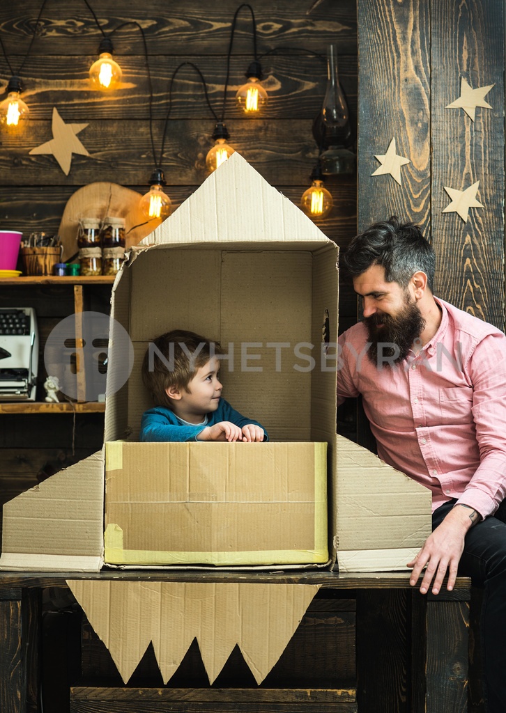Kid happy sit in cardboard hand made rocket. Parenthood concept. Child ...