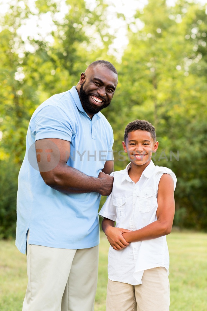 Father and his son laughing and playing at the park.