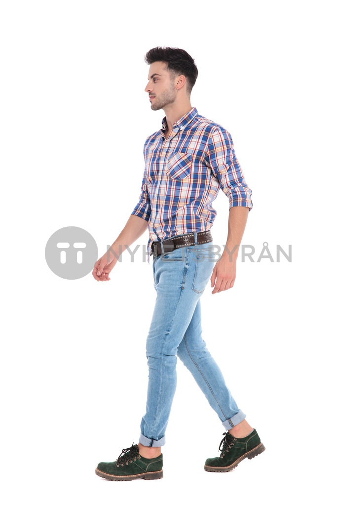 man wearing a shirt with red checkers walks to side