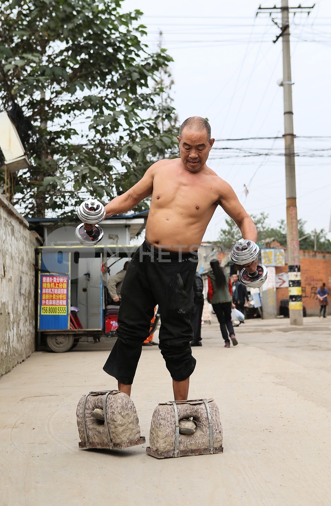 CHINA SICHUAN CHENGDU MAN WEARS STONE SHOES TO EXERCISE